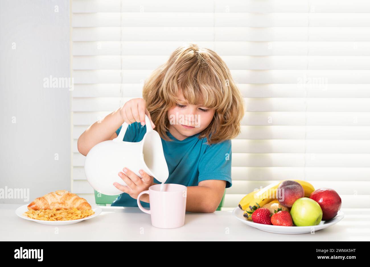 Kid pouring whole cows milk. Child boy eating organic healthy food ...