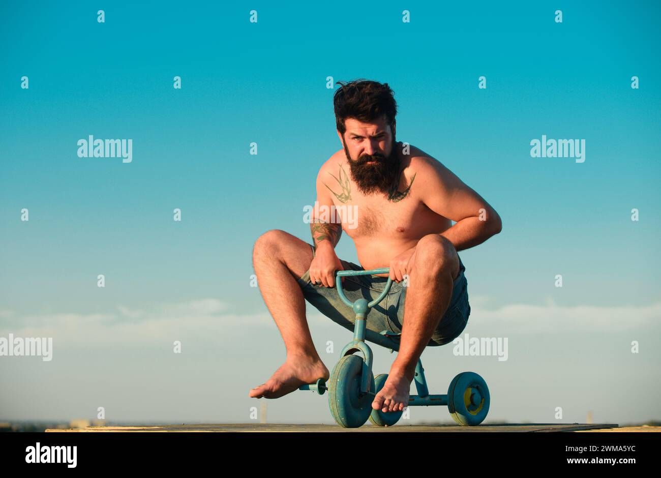 Crazy man riding a small bicycle. Funny bicycle rider. Comic man ride ...