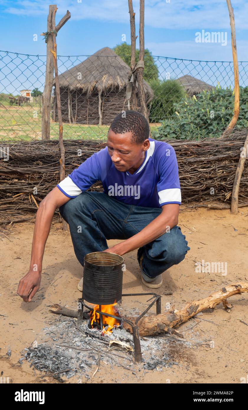 village african man cooking in the outdoors kitchen in the yard, in the ...