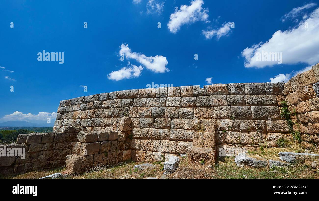 An ancient wall of stones under a blue sky with fluffy clouds, Ancient ...