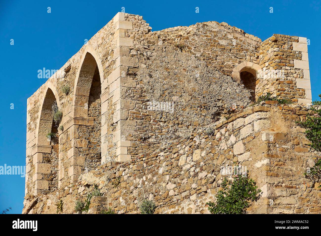 Part of an old stone fortress ruin with two arched windows in front of ...