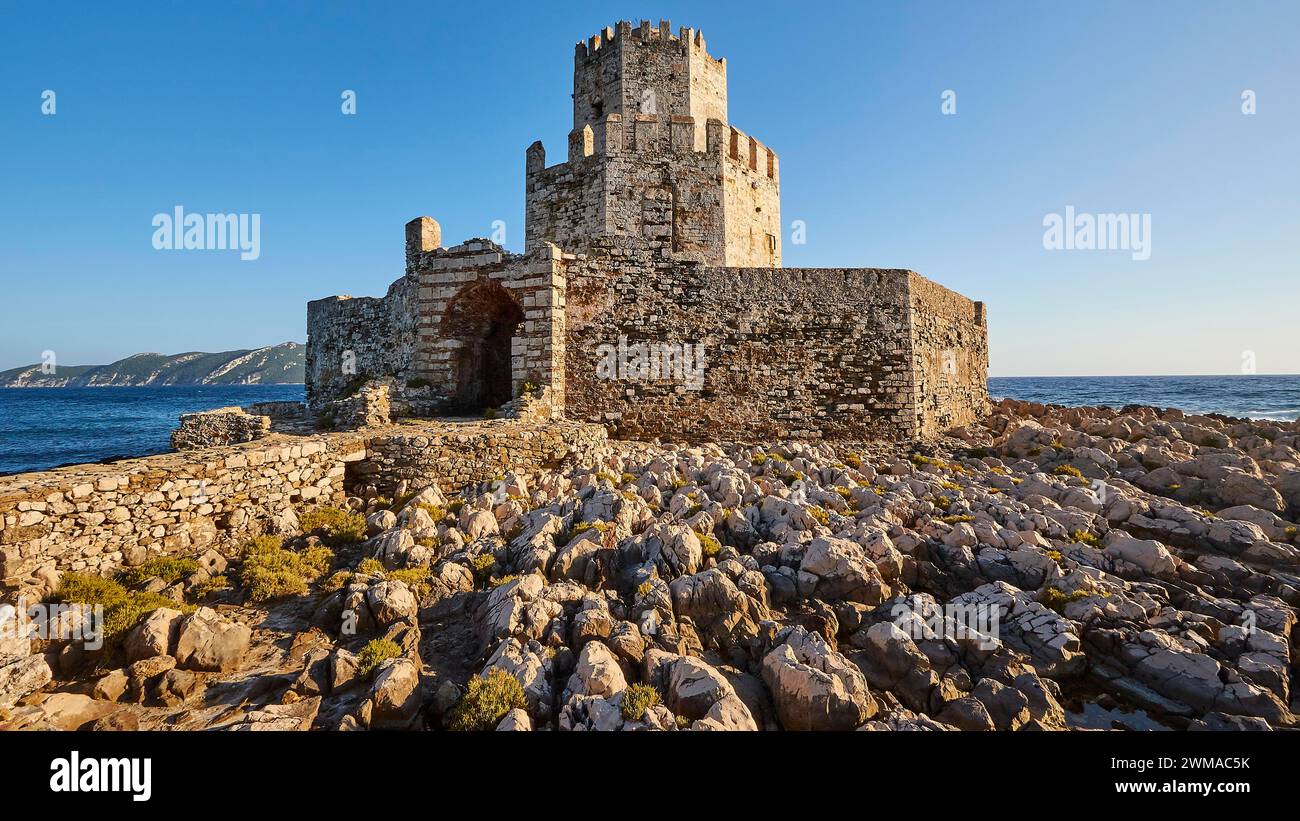 Old ruined fortress with tower-like structure against a clear blue sky ...