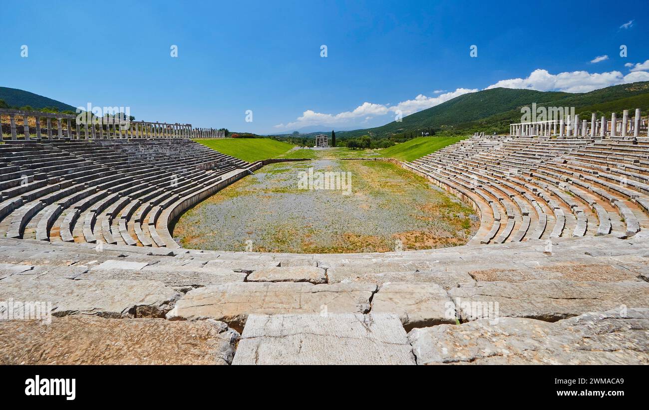 Empty ancient stadium with rows of seats in front of a hilly landscape ...