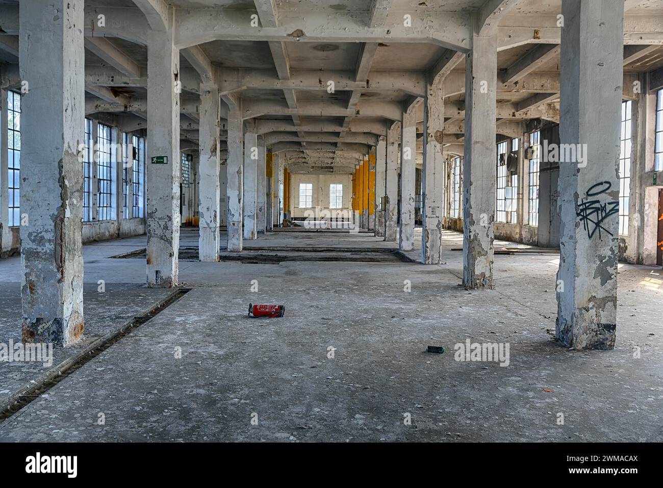 Empty dilapidated factory building, pillars, peeling paint, light ...