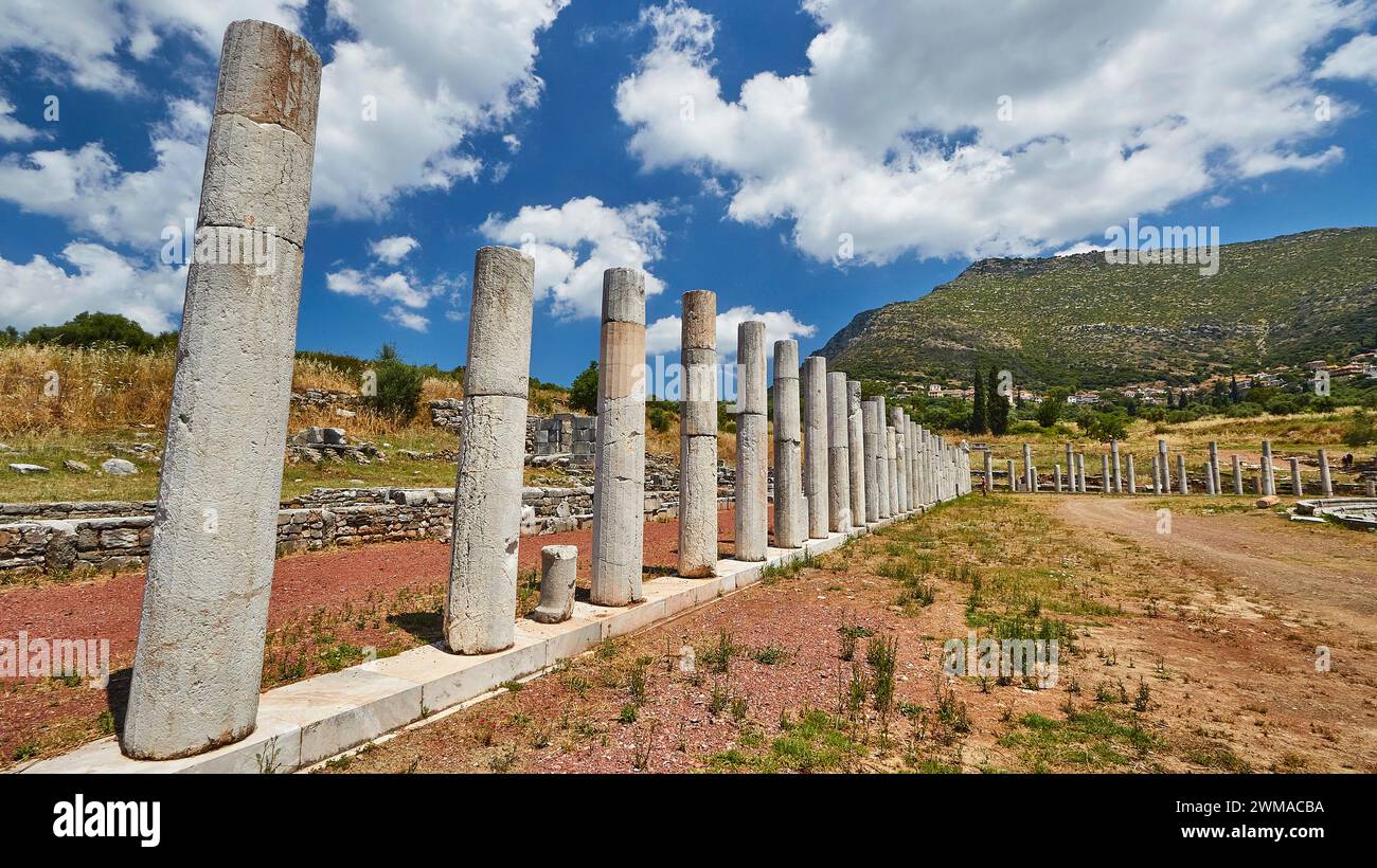 Row of ancient columns in front of mountains and blue sky with fluffy ...