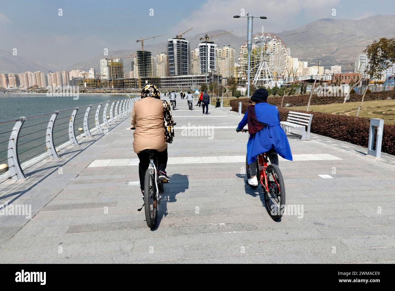 Two woman ride their mountain bikes at Lake Chitgar in Tehran, Iran. Lake Chitgar is an ...