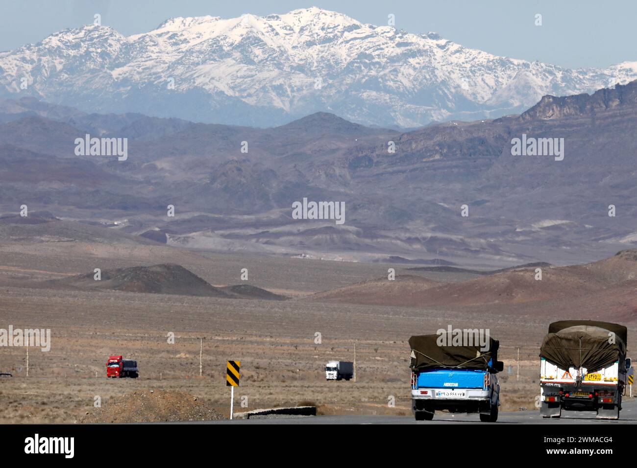 Truck on a motorway in the central desert of Iran, snow-capped ...