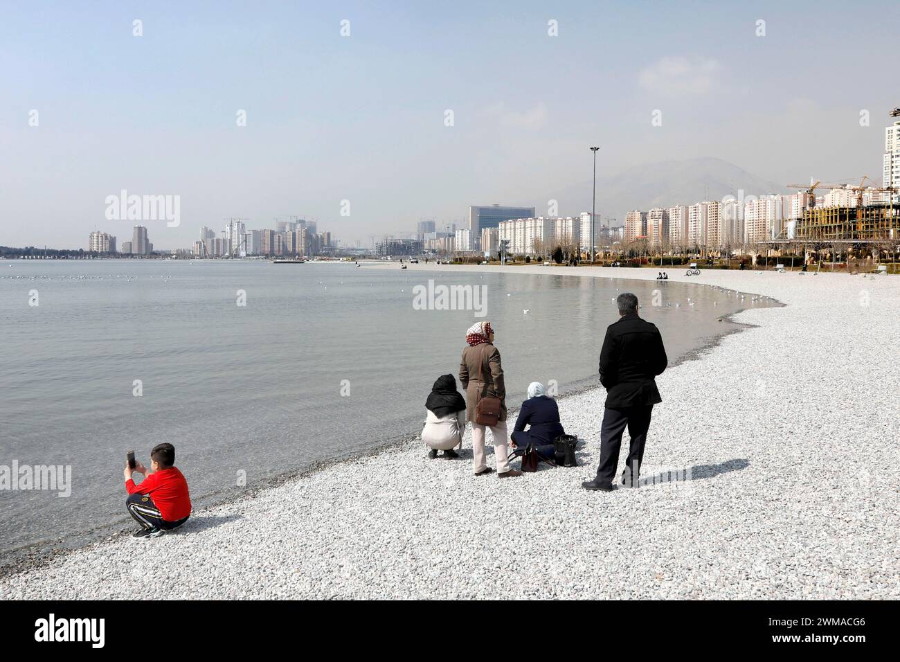 A family on the beach of Lake Chitgar in Tehran, Iran. Lake Chitgar is ...
