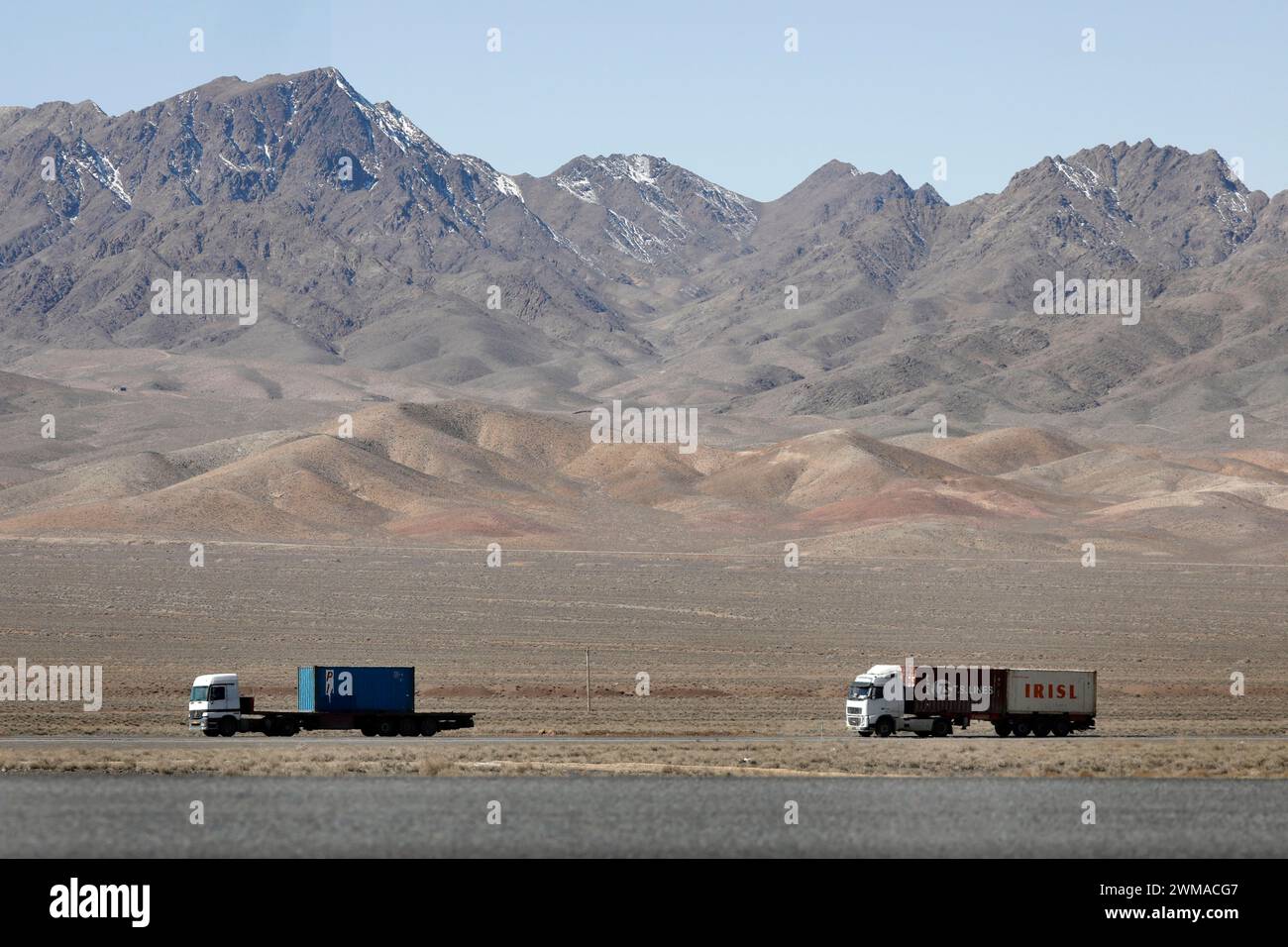 Truck on a motorway in the central desert of Iran, snow-capped ...