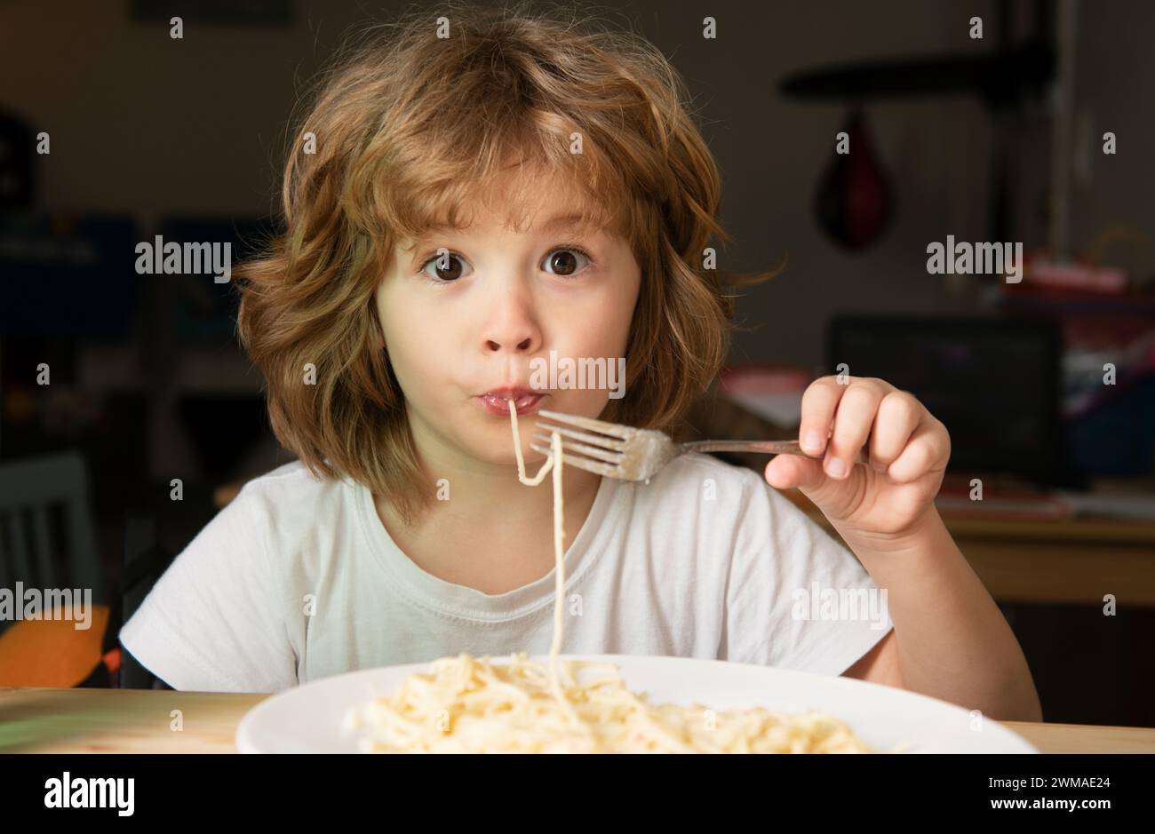 Funny child eating pasta, spaghetti. Kids face, little boy portrait ...