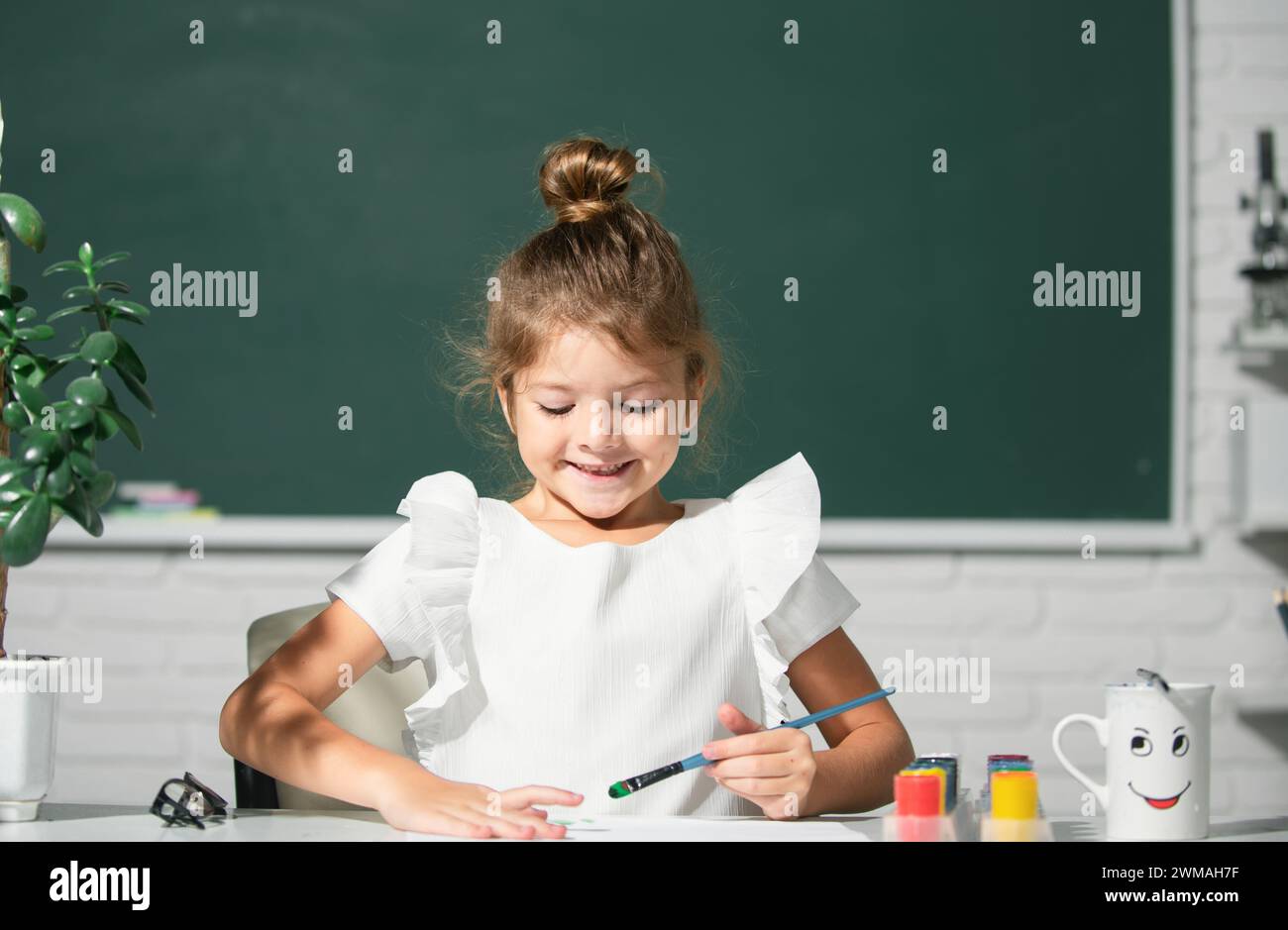 kid pupil learning painting. Cute little girl child painting with ...