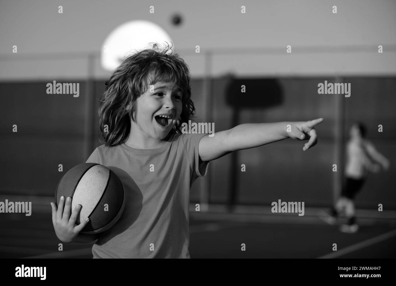 Cute child boy plays basketball, pointing up showing gesture. Active ...