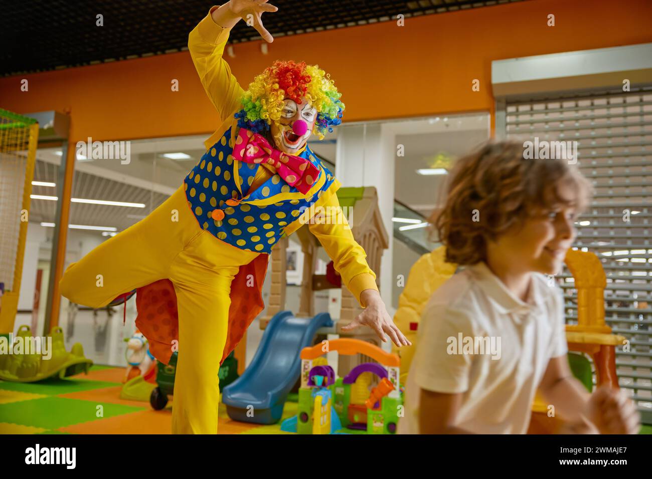 Funny clown playing with little boy at play center indoors Stock Photo ...