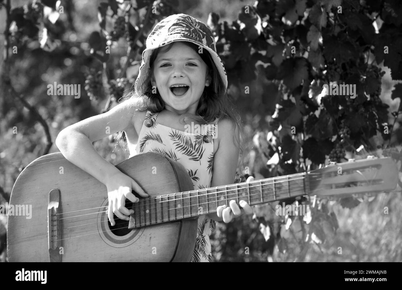Child with guitar outdoor. Smiling child playing outdoors in summer ...