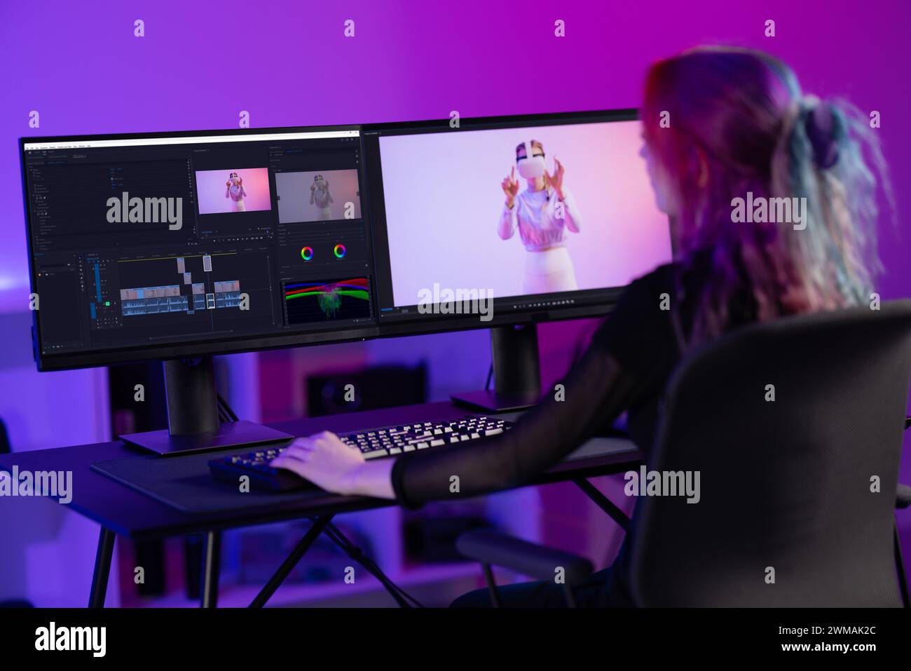 Creative digital artist editing video at work in modern office space ...