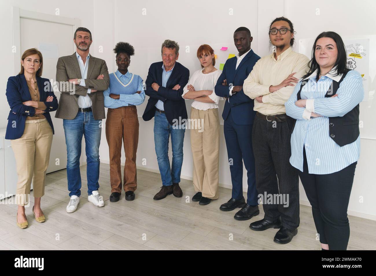 Full-length portrait of a multiracial office team including junior and ...