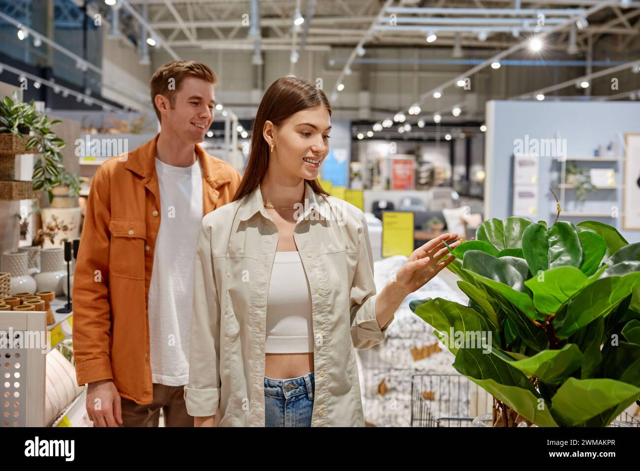 Happy man and woman couple walking through store racks with goods Stock ...