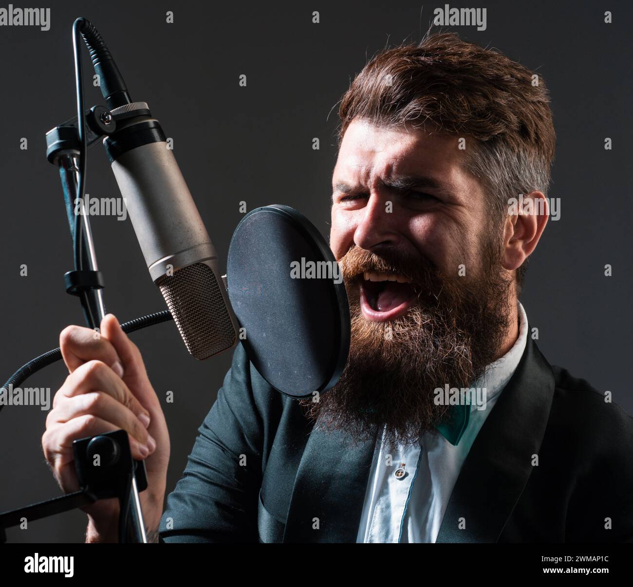 Classic singer is performing a song with a microphone while recording ...