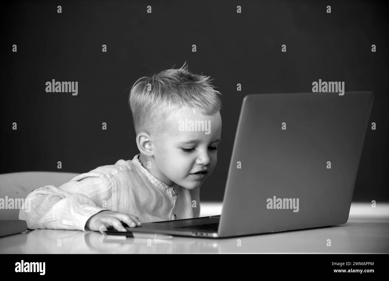 School boy learn lesson sitting at desk, studying online e-learning use ...
