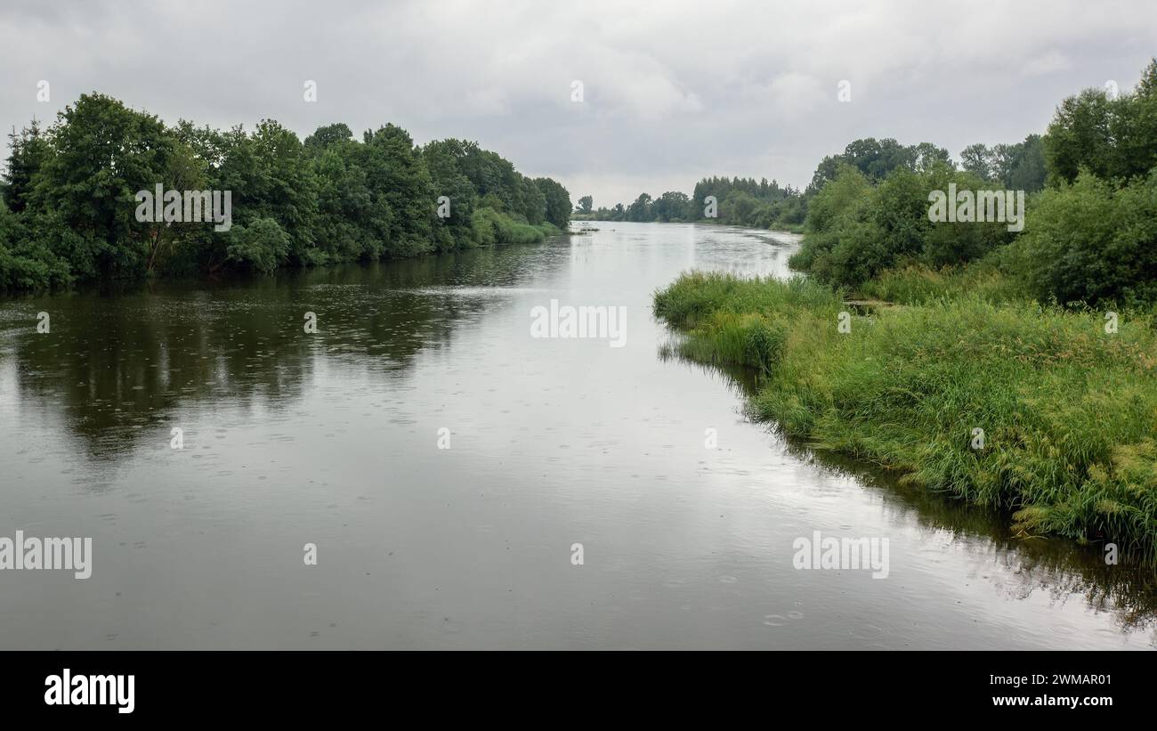Light summer rain and its drops falling into the river water. Calm ...