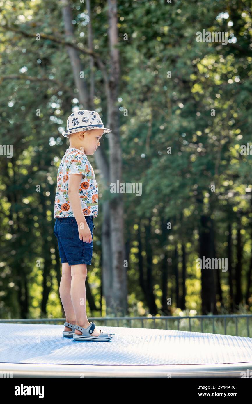 A little boy is standing on a sports balance disc in a city park on a ...