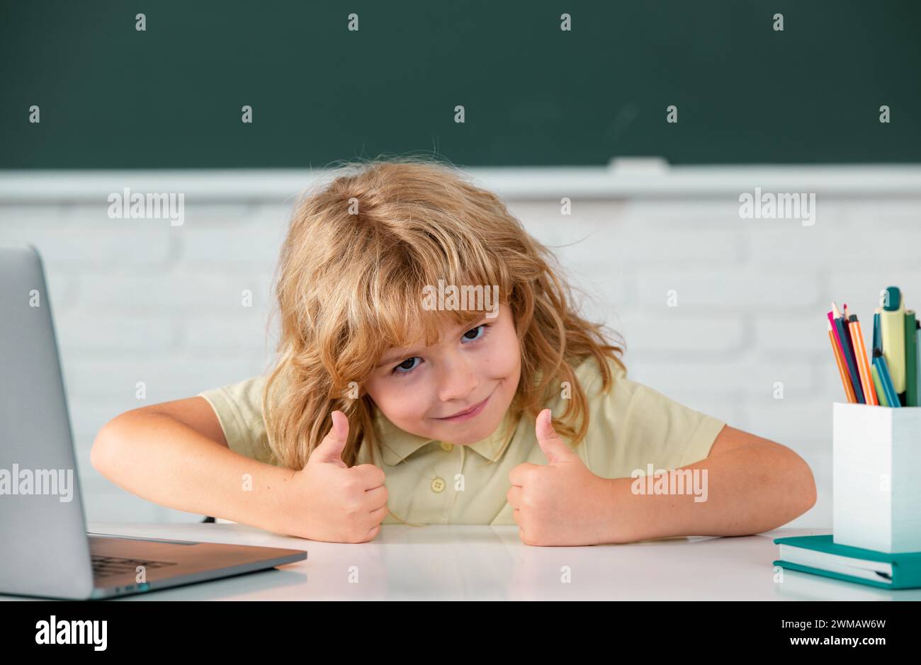 Elementary school kid with thumbs up working in computer class Stock ...