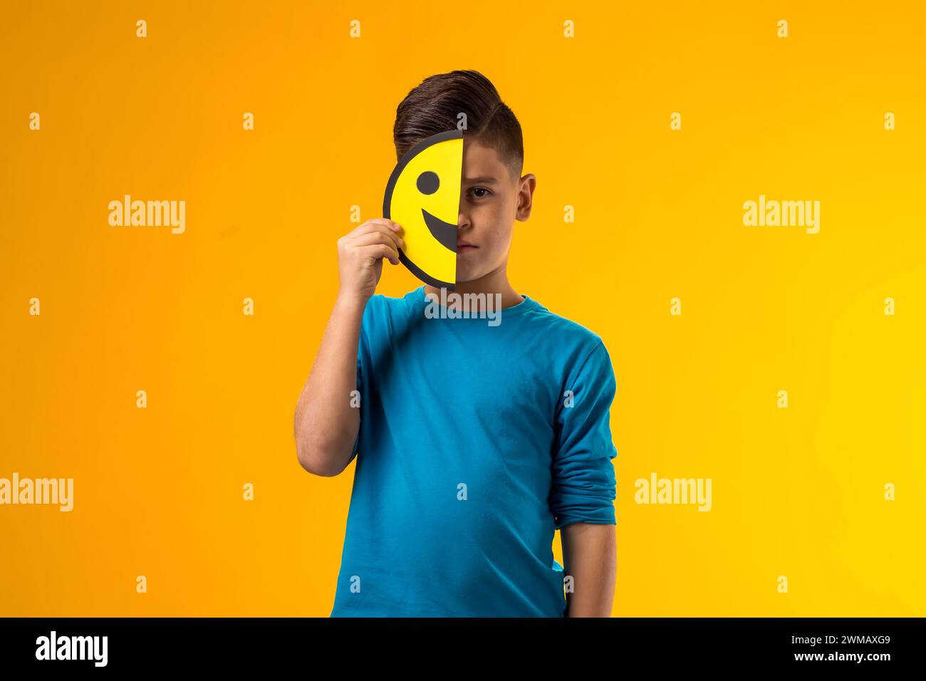 Portrait of child boy holds emoticons with happy emotion on half face ...