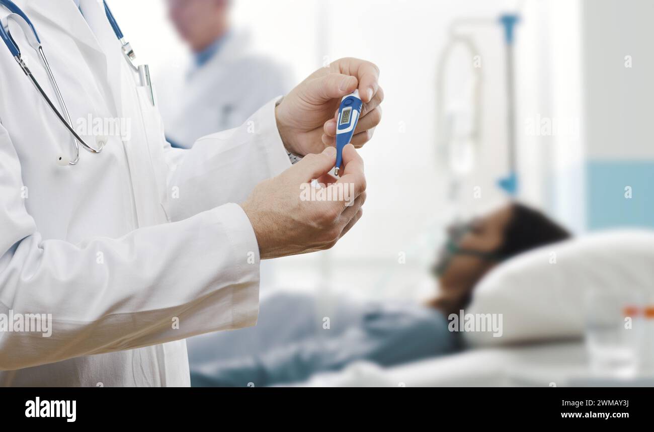 Professional doctor holding a thermometer, he is taking a patient's ...