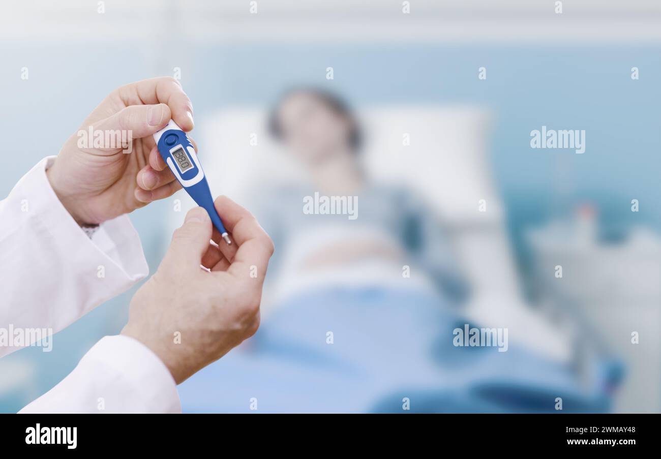 Doctor taking a patient's temperature using a digital thermometer, the ...