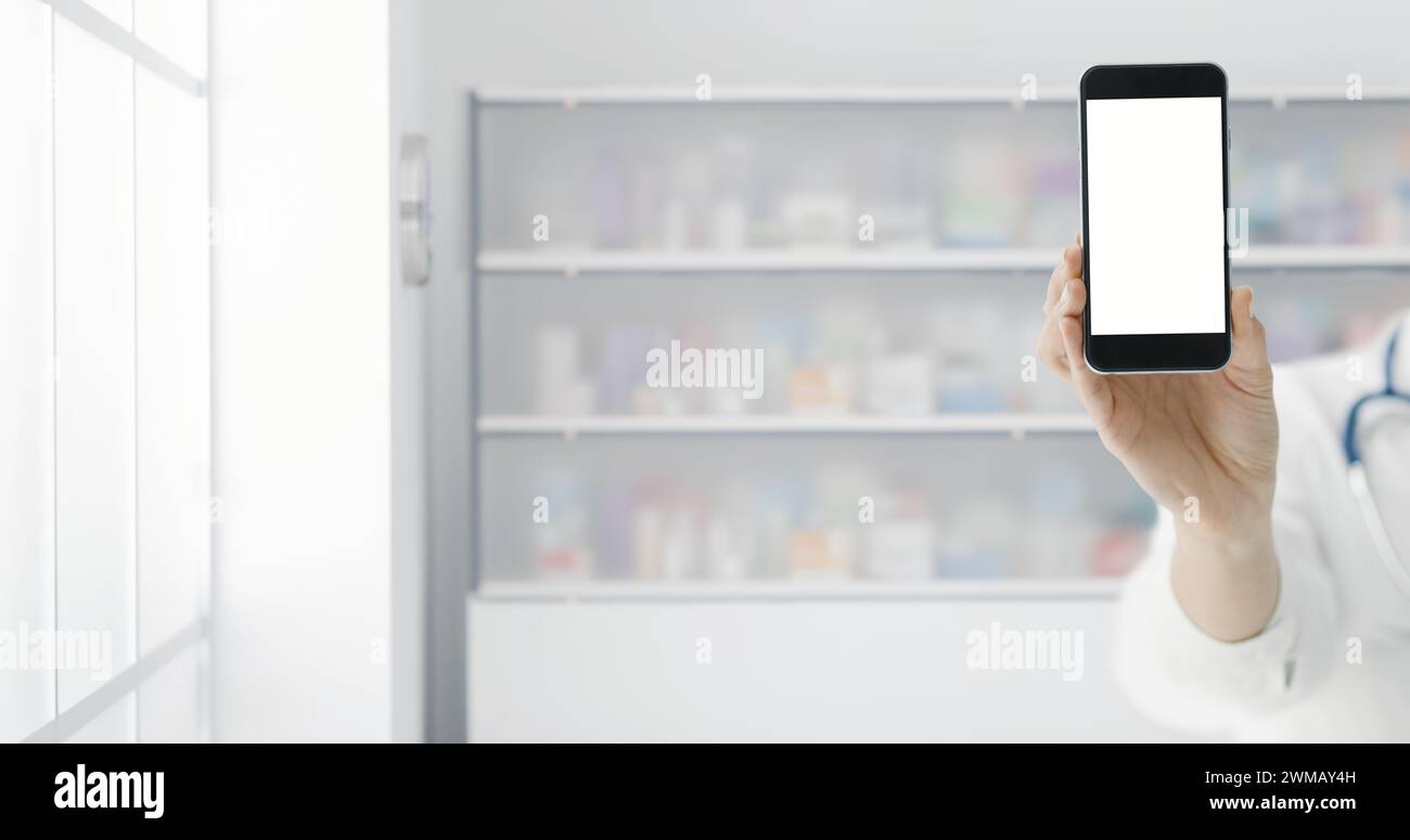 Pharmacist showing a smartphone with blank screen at the pharmacy ...