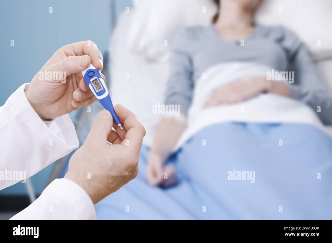 Doctor taking a patient's temperature using a digital thermometer, the ...
