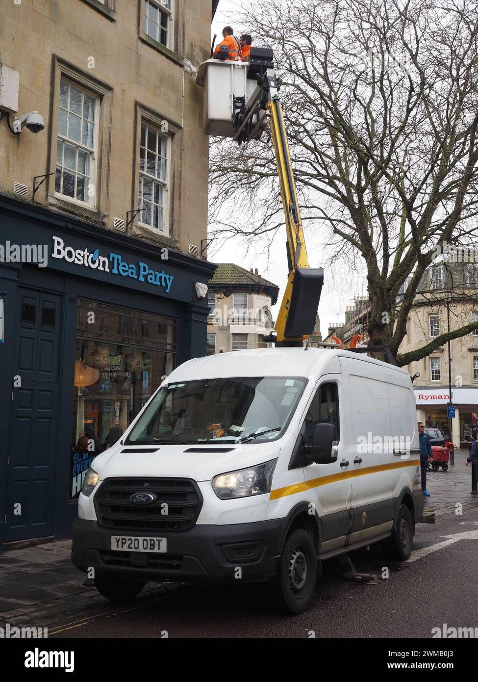 Workers using van-mounted cherry picker to install new wall mounted ...