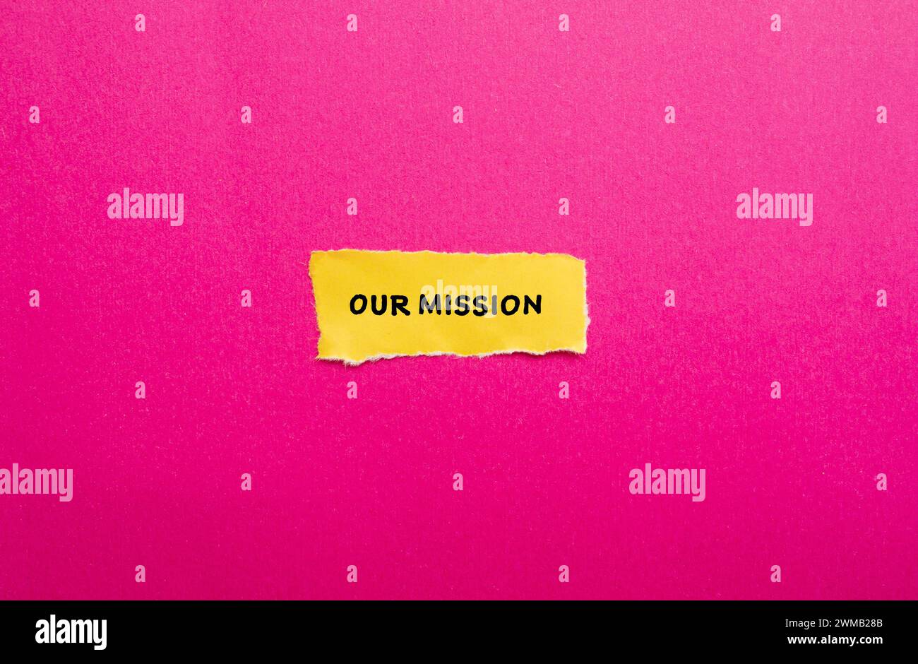 Our mission words written on yellow torn paper with pink background ...