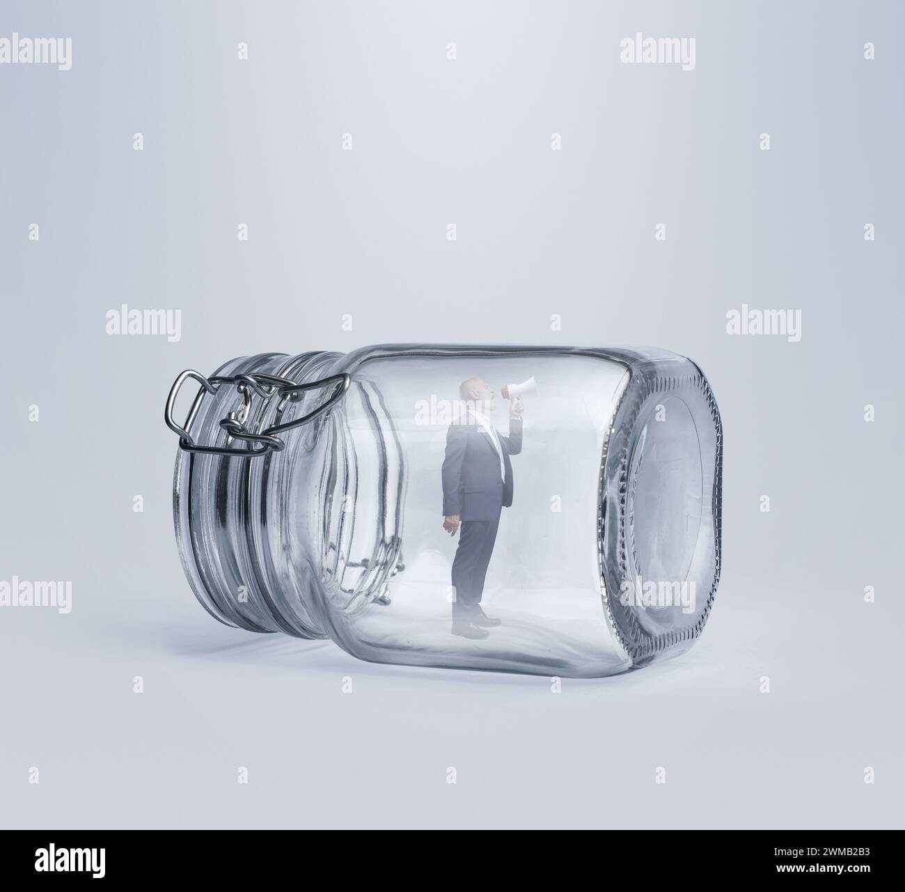 Corporate businessman trapped inside a glass jar, he is using a ...