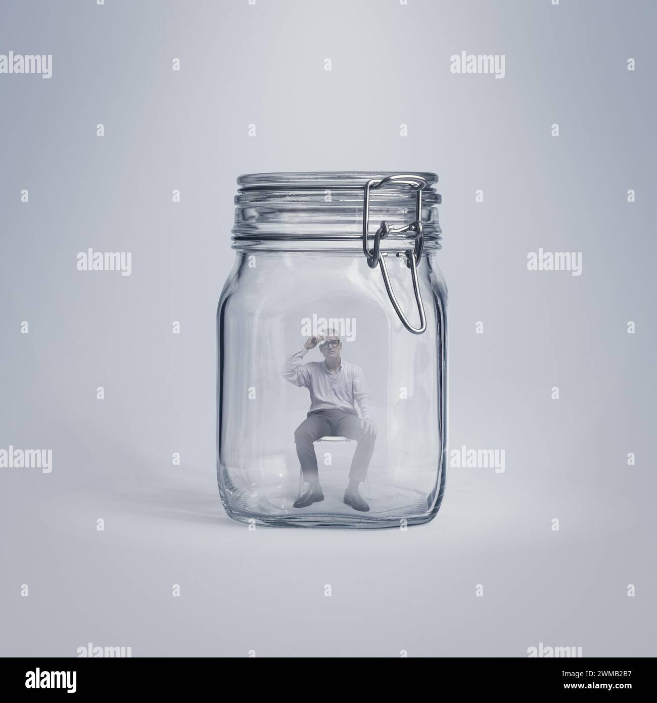 Stressed sweating businessman trapped in a glass jar, isolation and ...