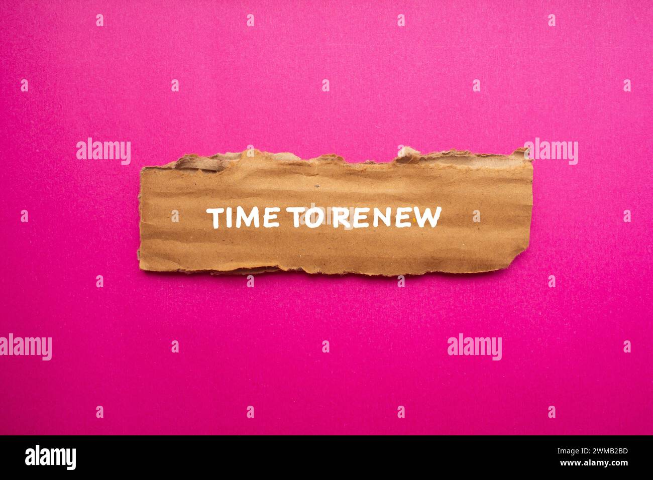 Time to renew words written on torn paper with pink background ...