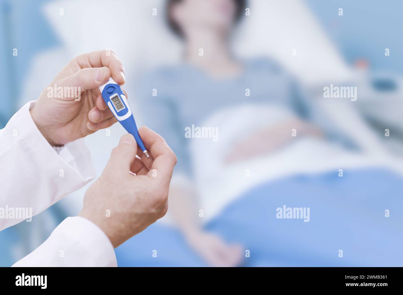 Doctor taking a patient's temperature using a digital thermometer, the ...