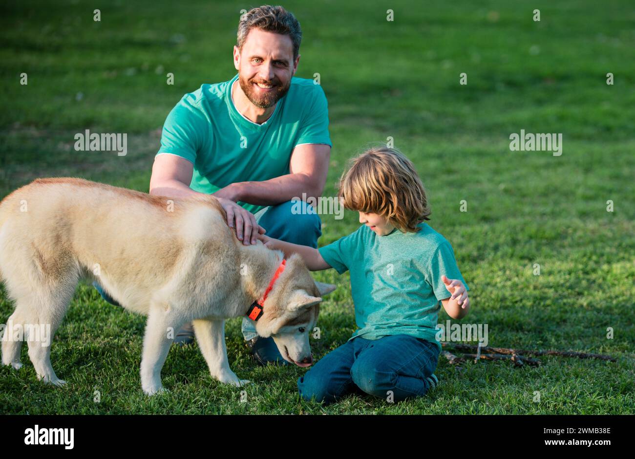 Father and son with pet dog relaxing on nature in park Stock Photo - Alamy