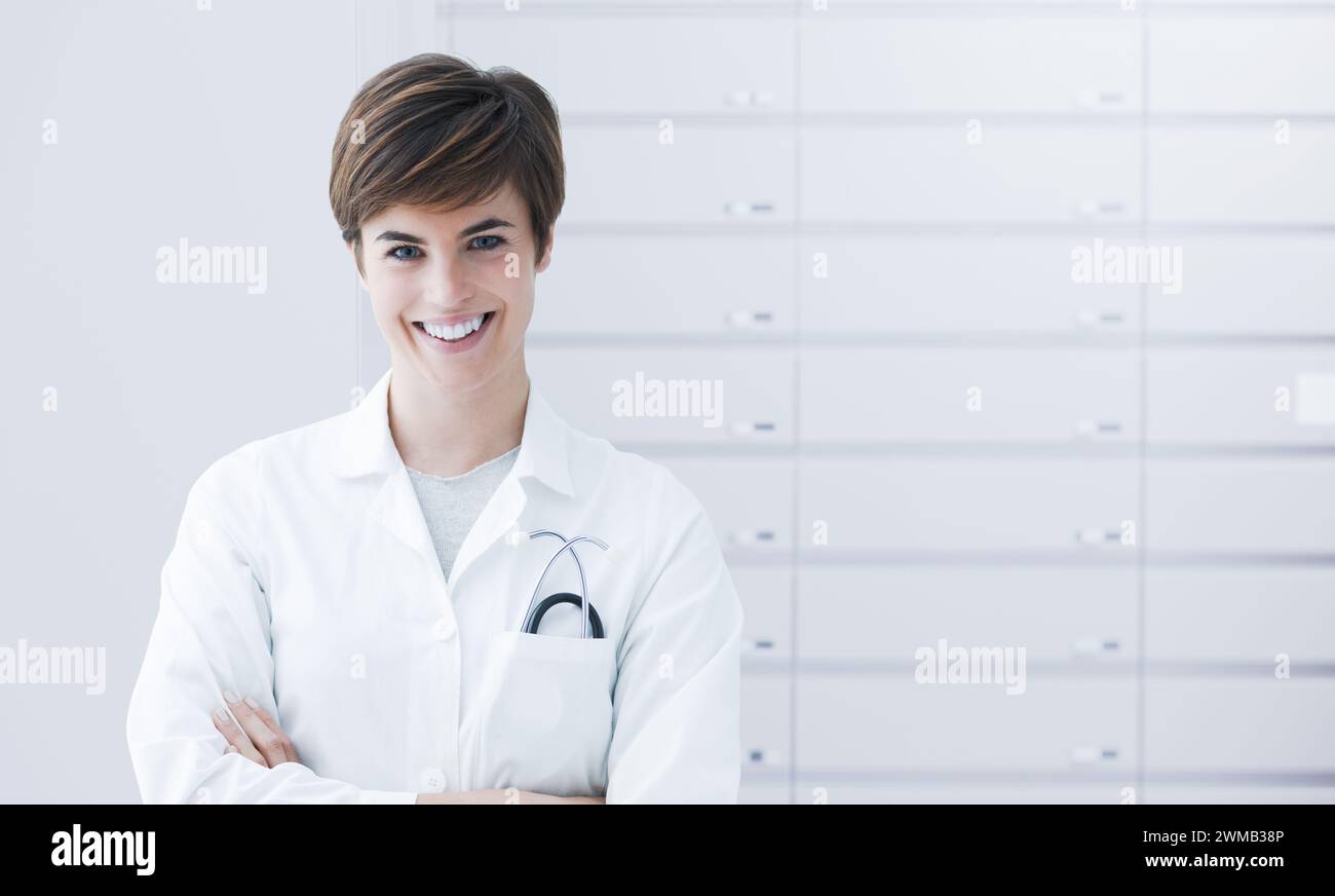 Professional female pharmacist posing in front on pharmacy drawers ...