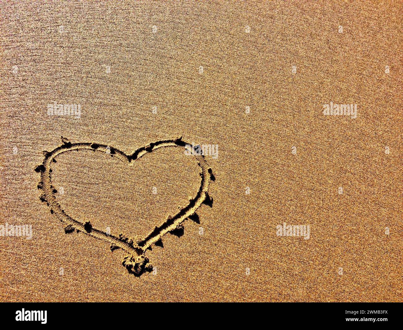 A heart is etched into a sandy surface, showing a clear contrast Stock ...