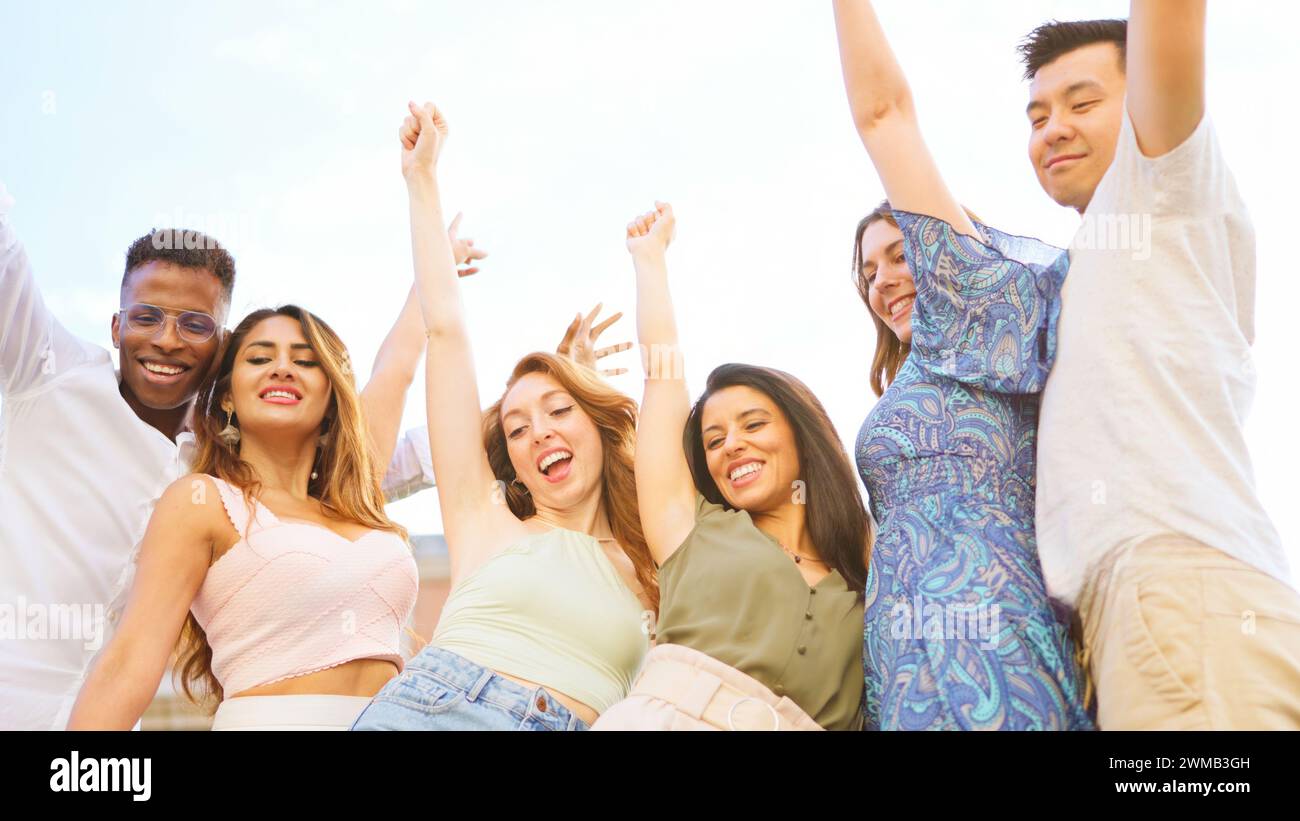 Happy group of friends raising the arms while smiling Stock Photo - Alamy
