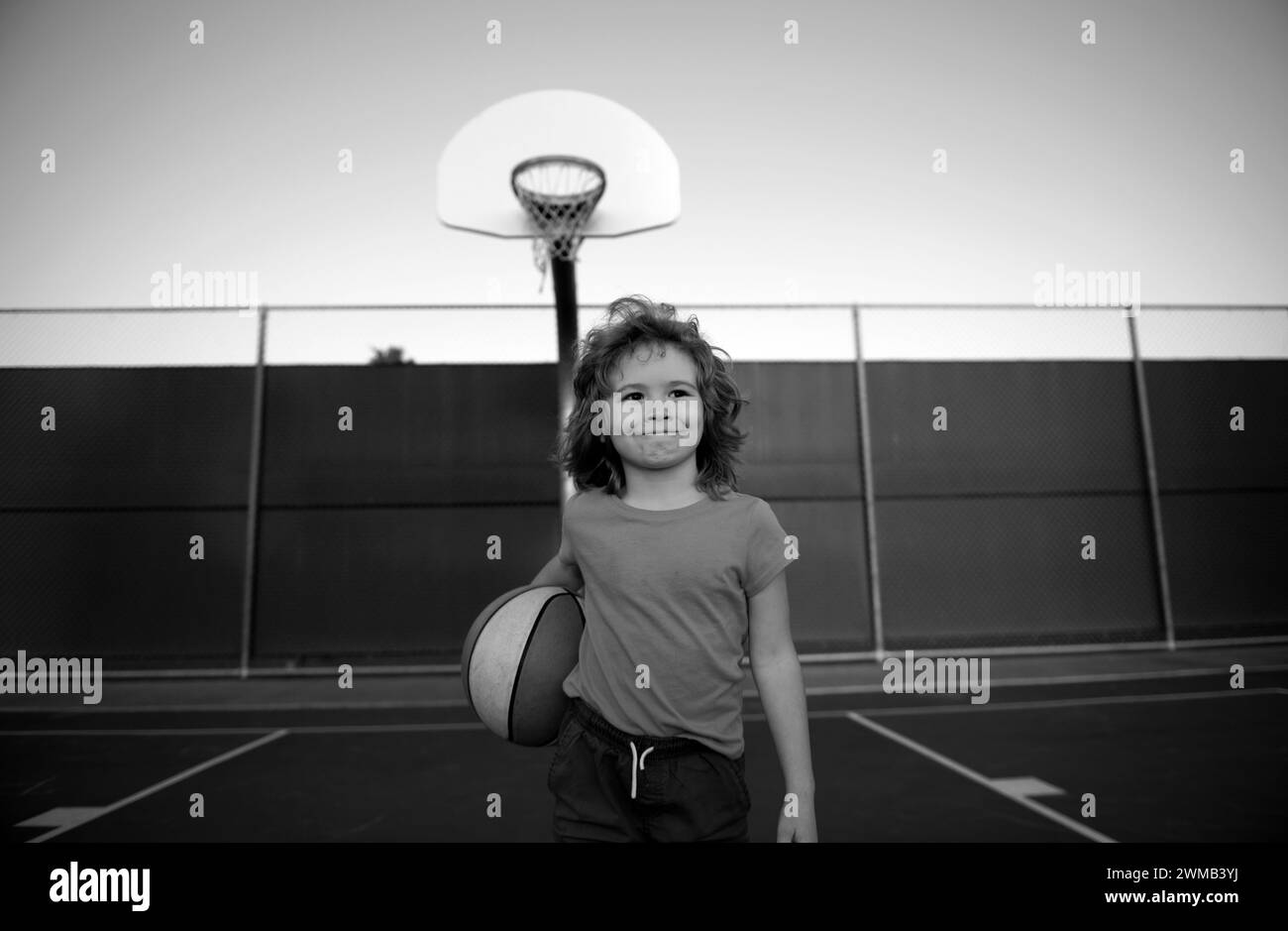 Little caucasian sports kid playing basketball holding ball with happy ...