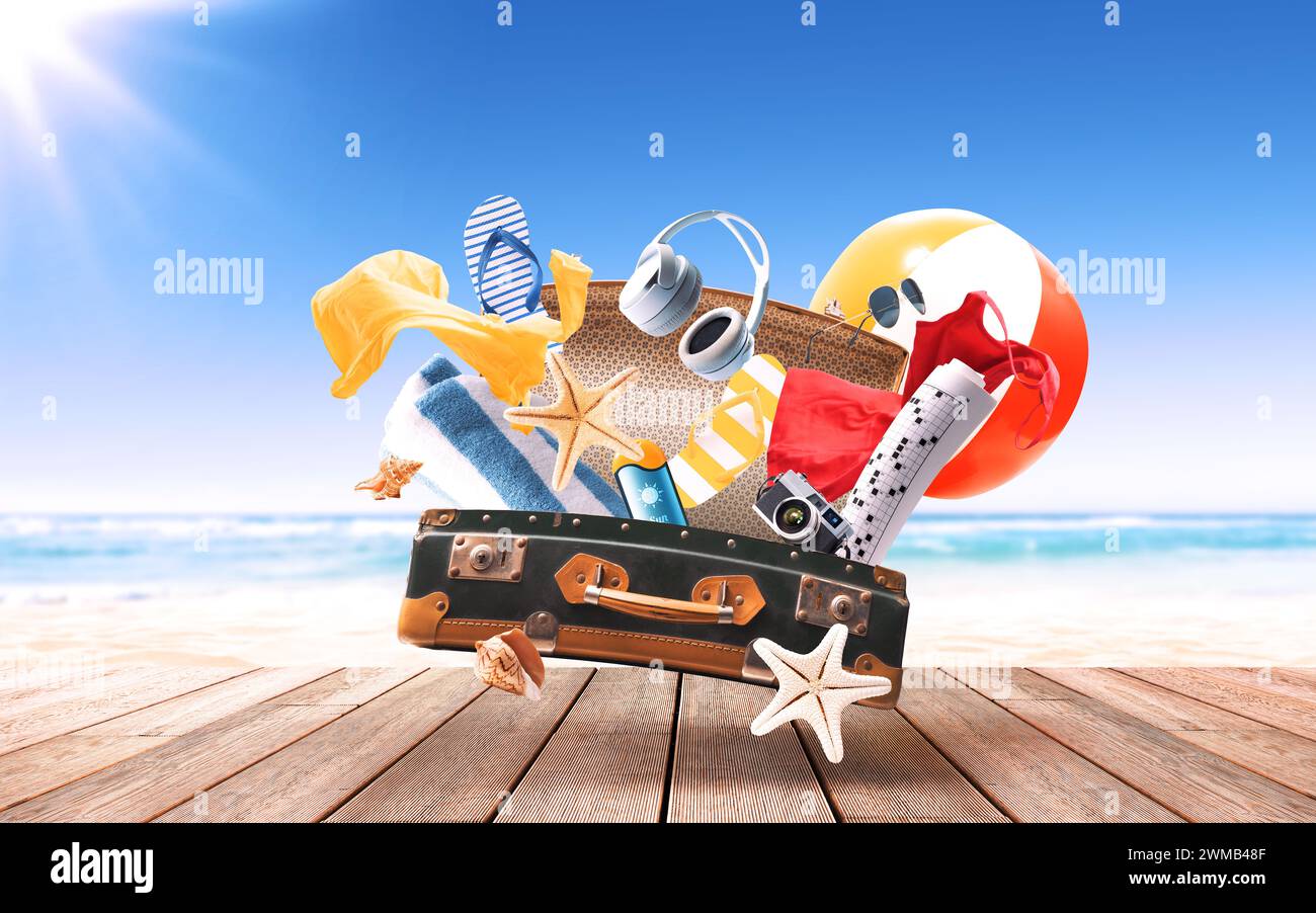 Flying open suitcase with accessories and beach in the background ...