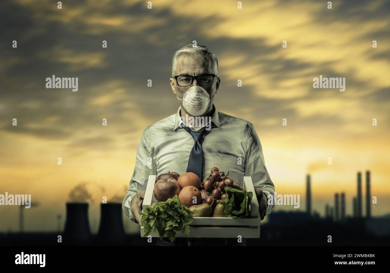 Businessman with protective mask holding a crate with polluted ...