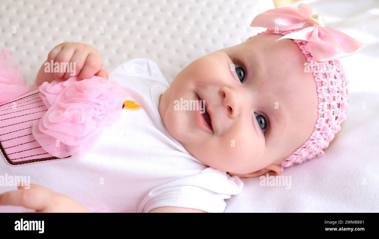 Sweet baby girl with pink ribbon Stock Photo - Alamy
