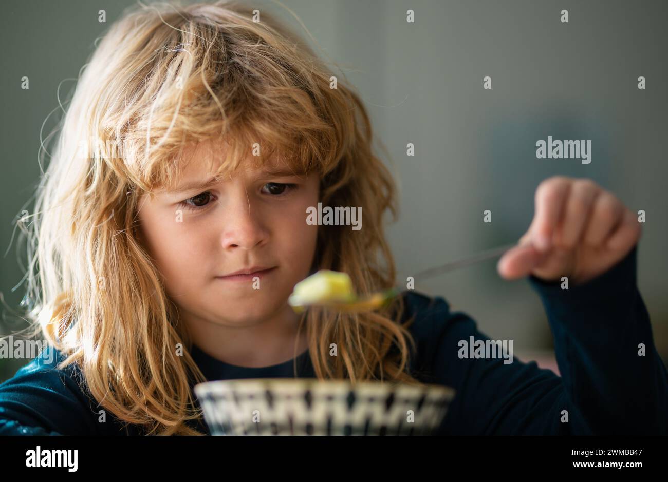 Cute child eating breakfast at home. Sad boy eating healthy chicken ...