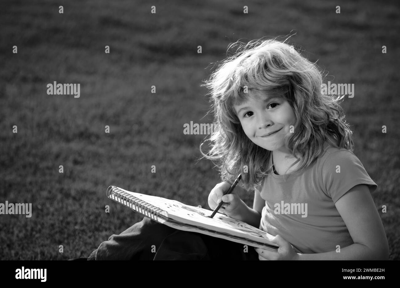 Child boy draws in park having fun on nature background. Happy child ...