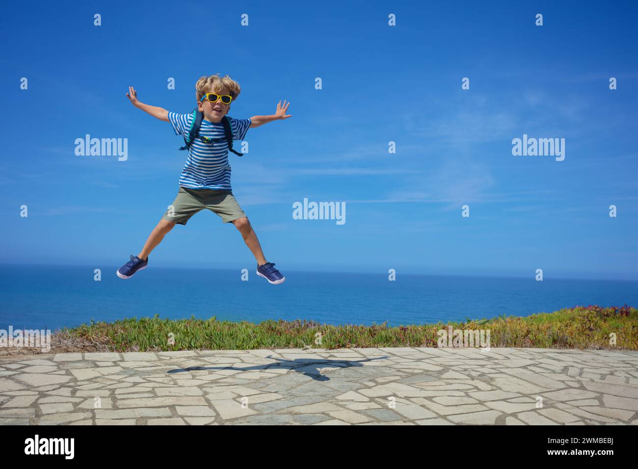 Happy blond kid jump high on sea background with sunglasses Stock Photo ...