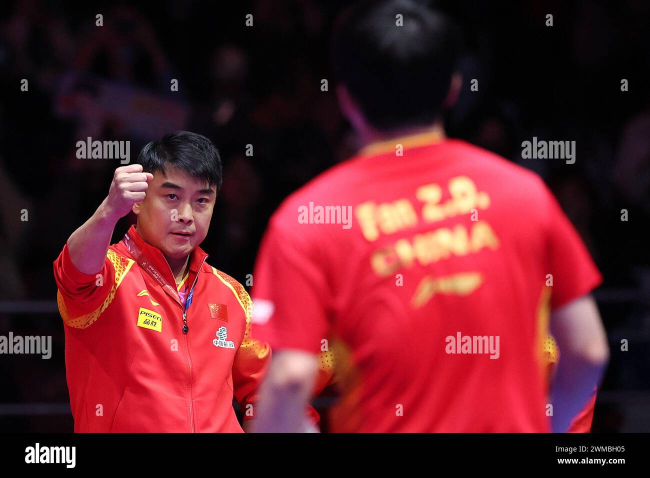 Busan, South Korea. 25th Feb, 2024. China's coach Wang Hao (L) cheers for Fan Zhendong in the ...