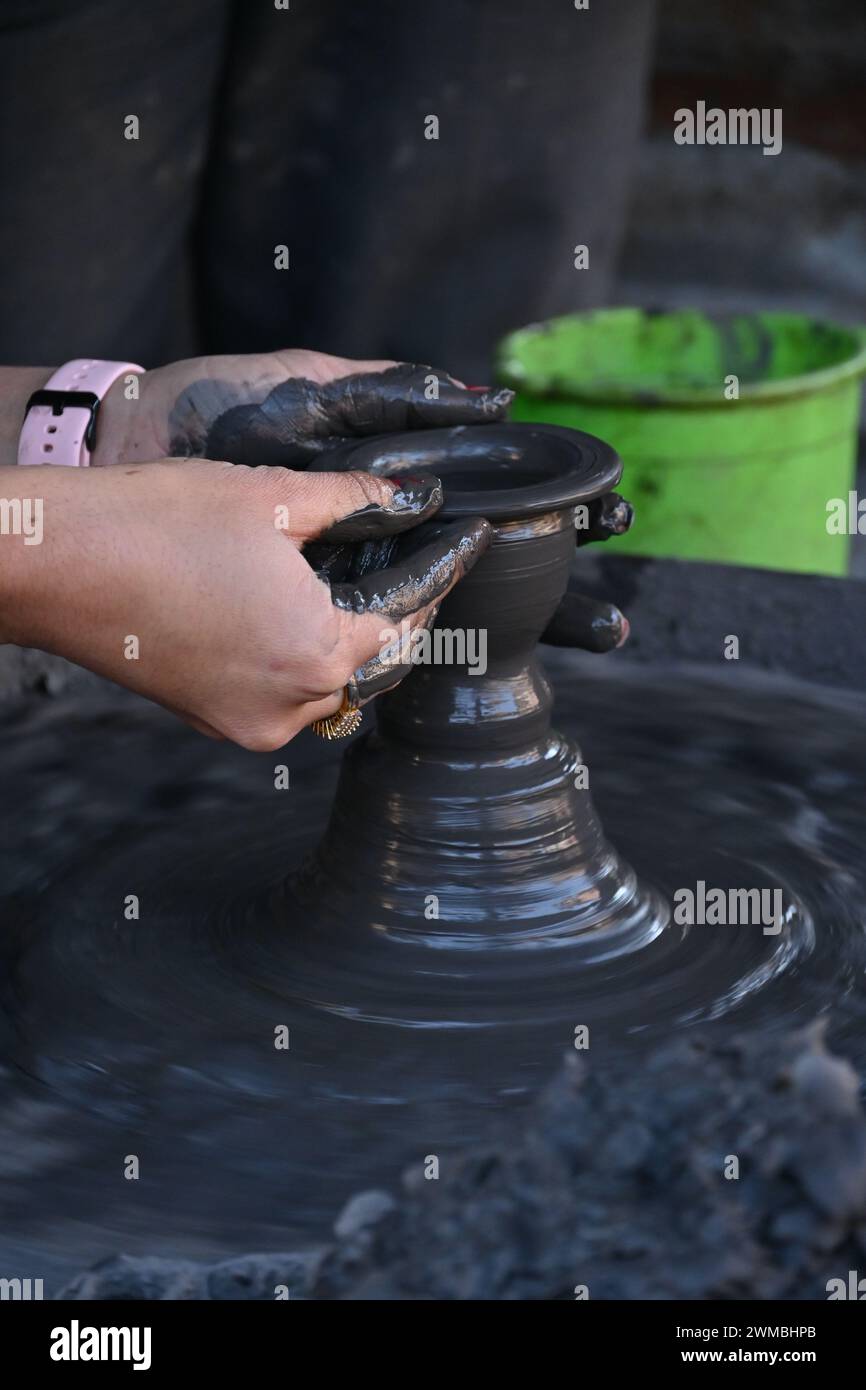 Closeup of two hands modeling clay during a pottery workshop in Pottery ...